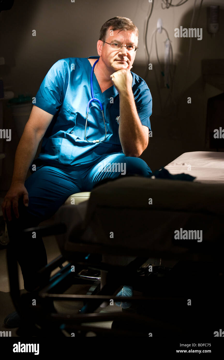 Smiling mature doctor sitting hi-res stock photography and images - Alamy