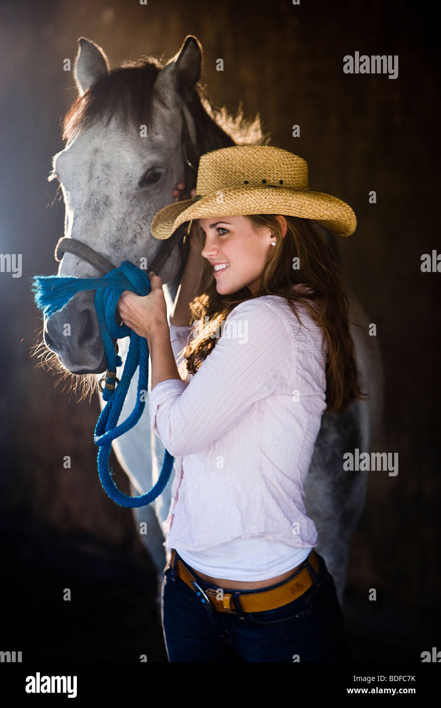 Young cowgirl with white Gelding horse in stable Stock Photo - Alamy