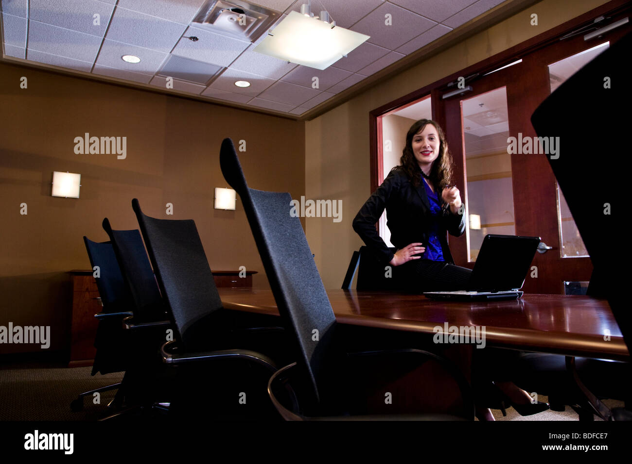Young woman in conference room with laptop Stock Photo - Alamy