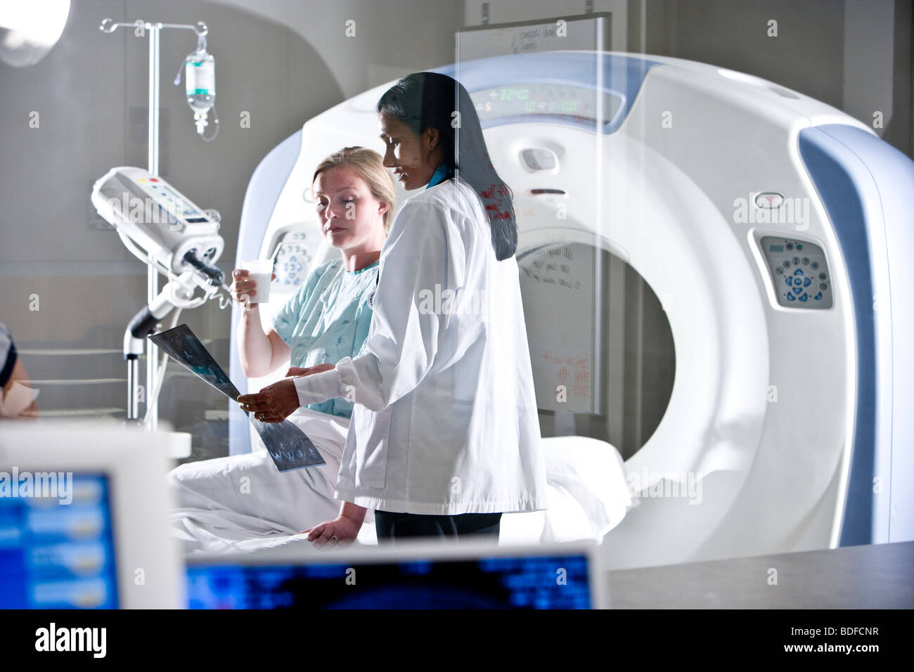 Radiologist reviewing CAT scan images with patient Stock Photo - Alamy