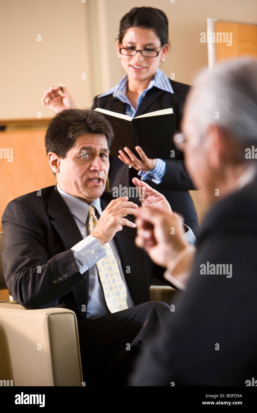 Hispanic businessmen and businesswoman talking in office Stock Photo ...