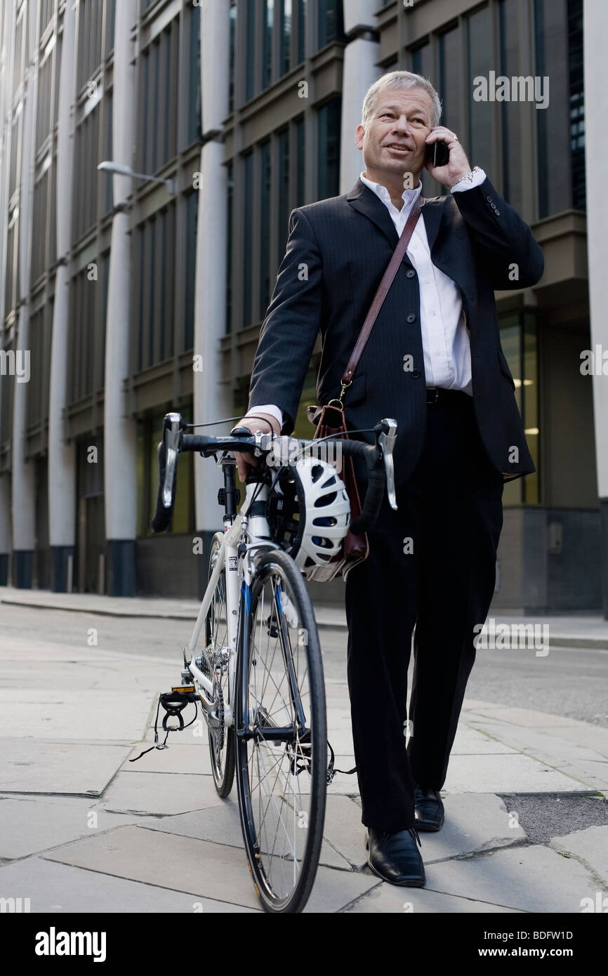 Businessman pushing bicycle Stock Photo - Alamy