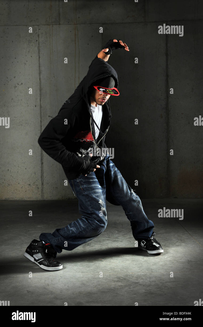 African American breakdancer performing over an industrial background ...