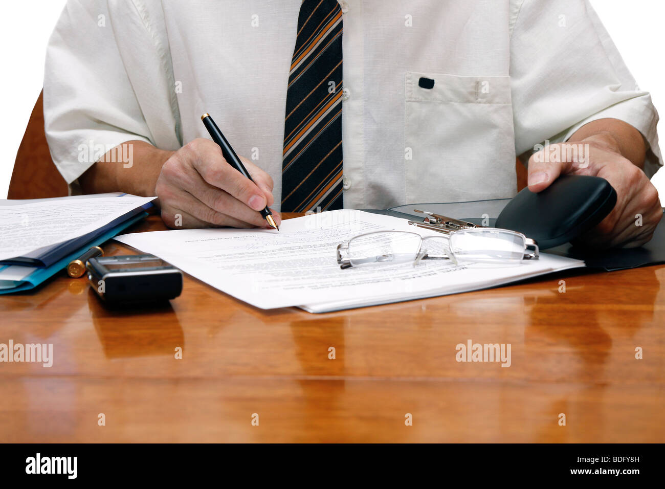 The businessman, sitting at a table, signs documents Stock Photo - Alamy