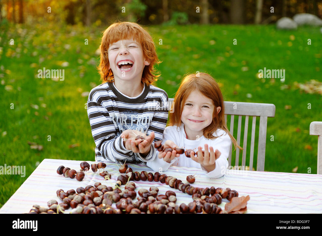 Girl and a boy playing in the garden with chestnuts, chestnut figures ...