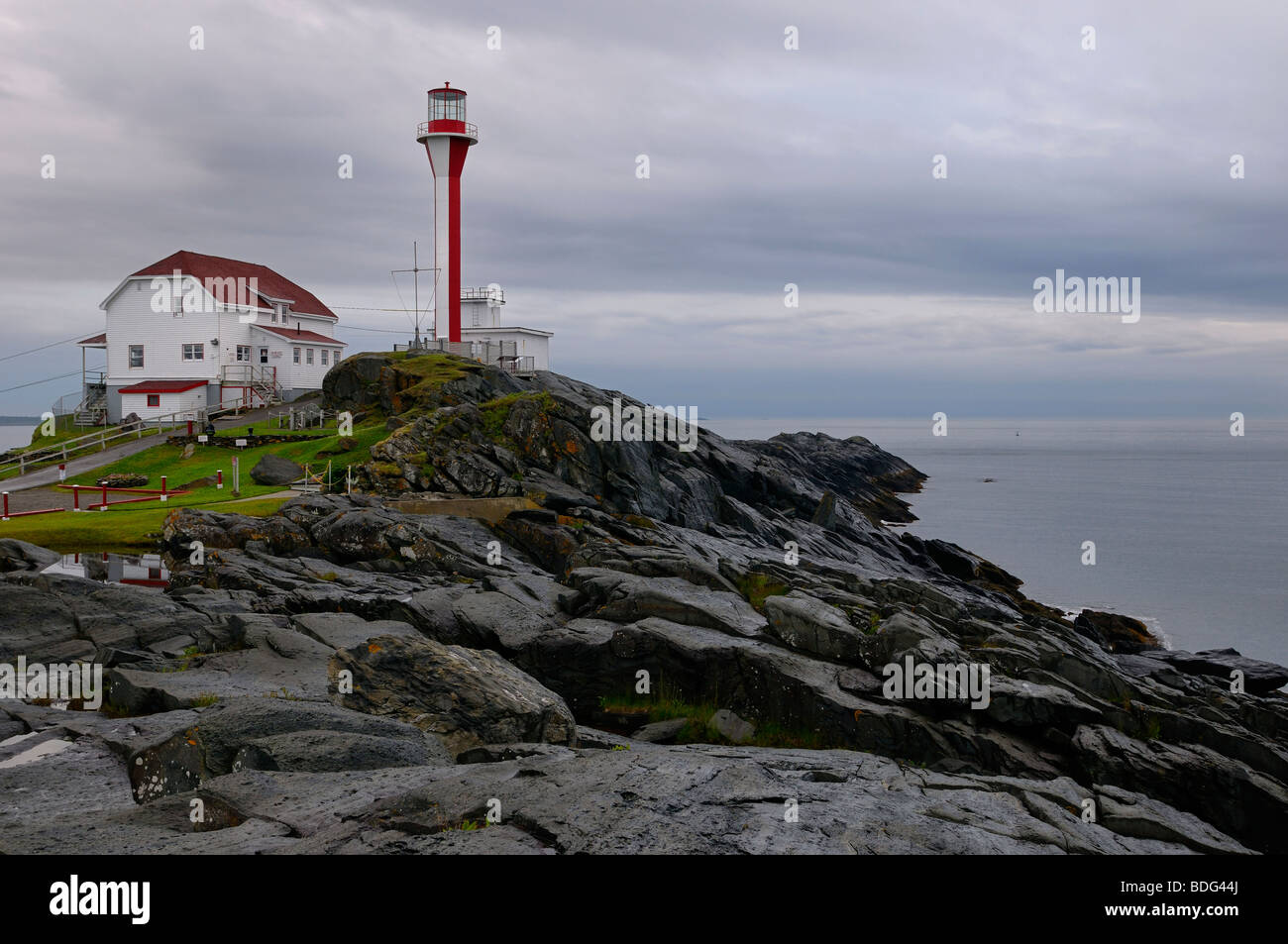 Cape Forchu lighthouse on the Atlantic Ocean with clouds and wet rocks ...