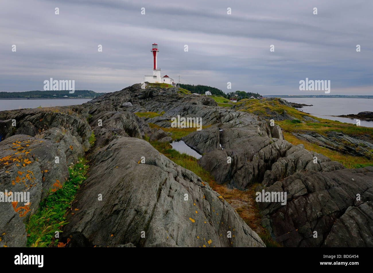 Cape Forchu lighthouse peninsula on the Atlantic Ocean with wet rocks ...
