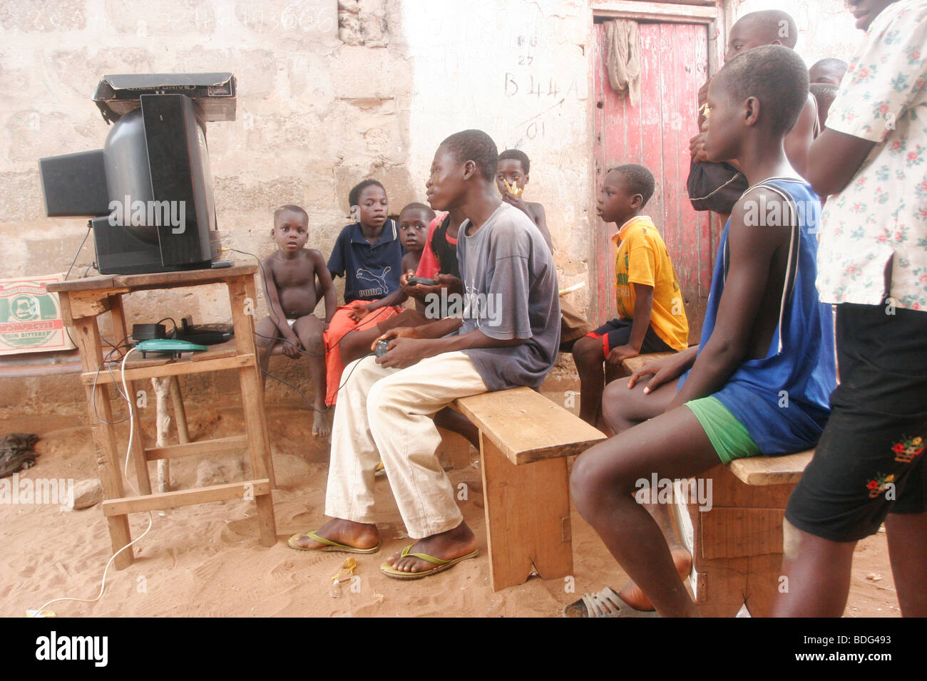 Children playing computer games in the street. Butre Village. Near ...