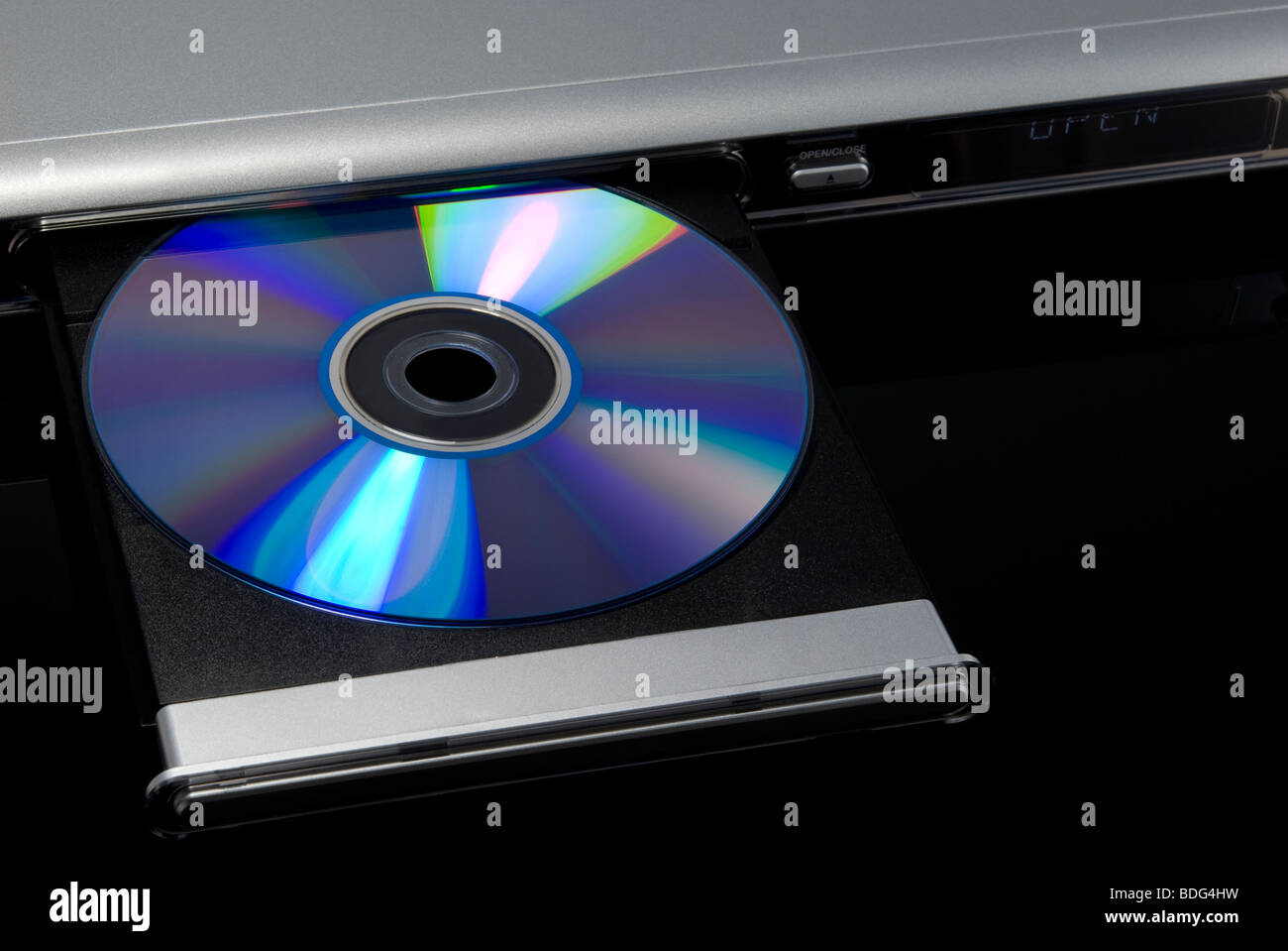 DVD disc inserted in DVD player disc tray isolated on black background ...