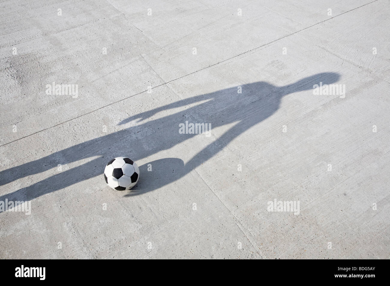 Shadow holding a football Stock Photo - Alamy
