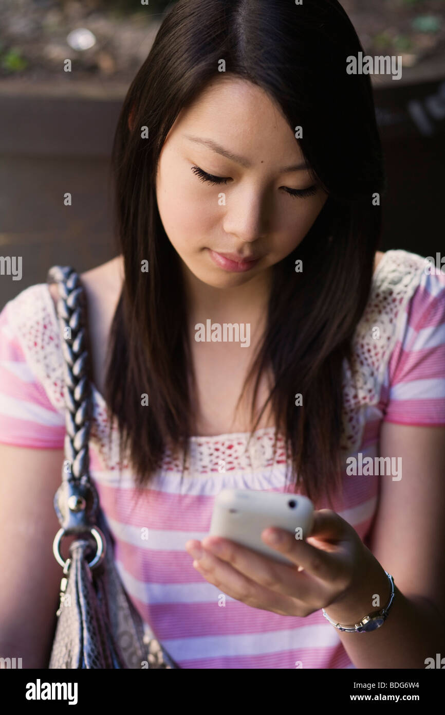 A young woman texting on her cell phone Stock Photo - Alamy