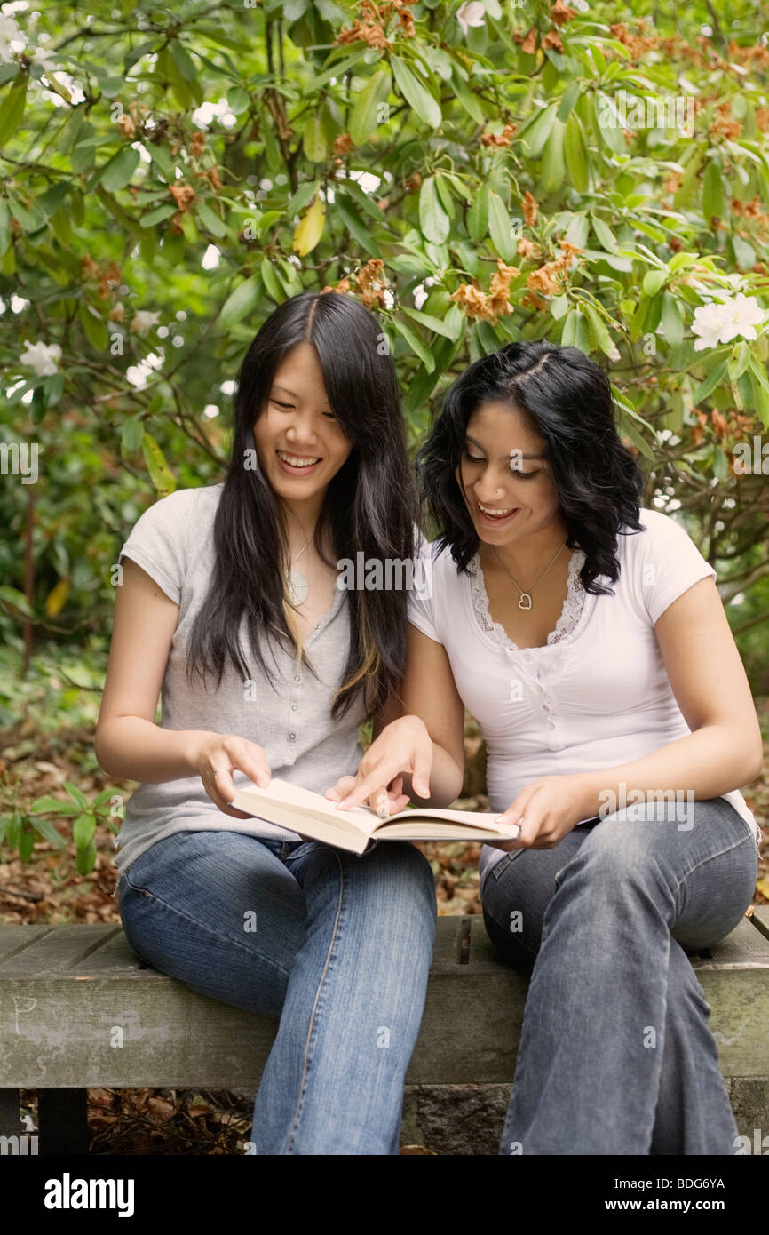 Two teenage girls reading a book together, Vancouver, British Columbia ...
