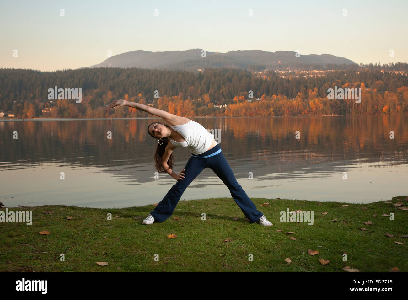 A young woman stretching in a park, Port Moody, Vancouver, British ...