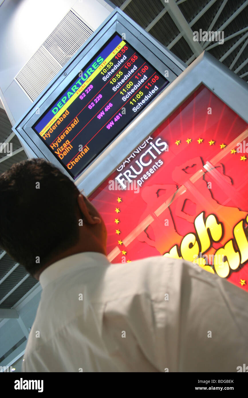 Man passenger checking flight information screen Stock Photo - Alamy