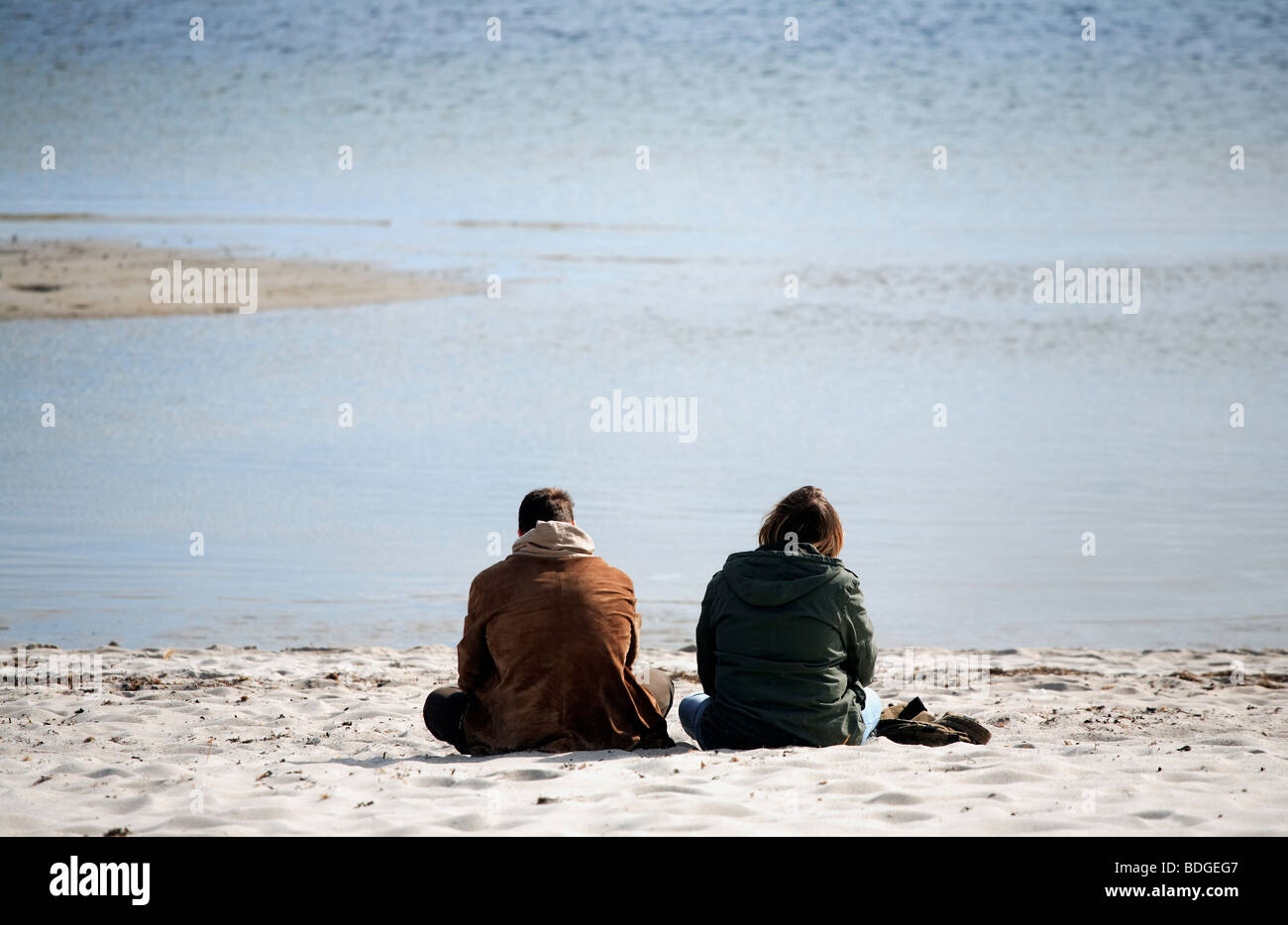 Couple sitting on the beach, Eckernfoerde, Germany Stock Photo - Alamy