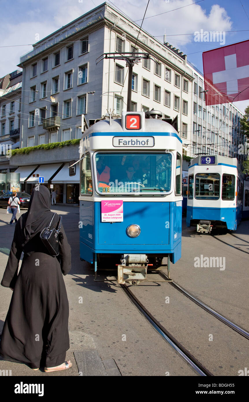 Muslim female tourist waiting for Vintage Zurich tram to turn onto ...