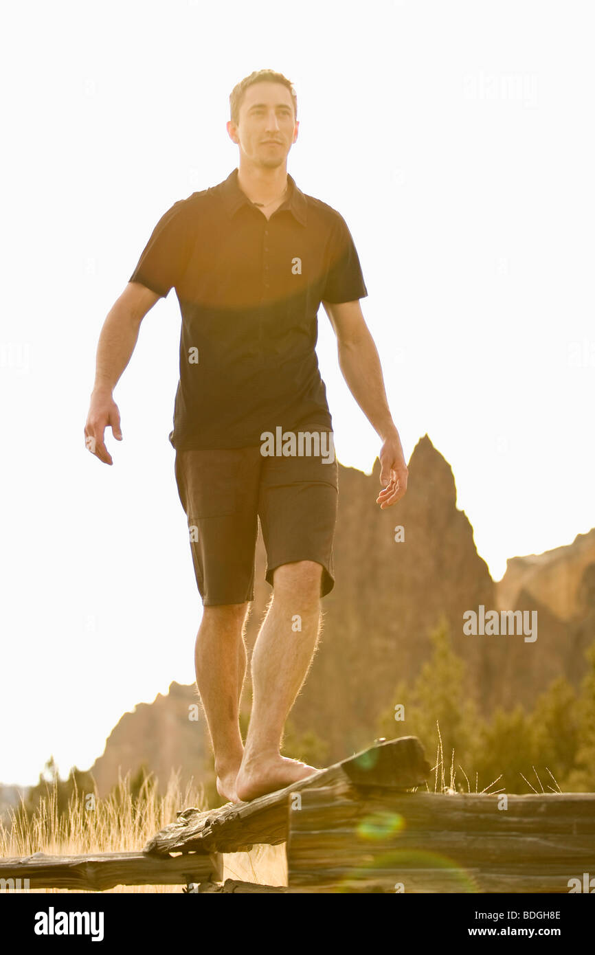 A man does his best to balance while walking on thin log. (solar flare ...