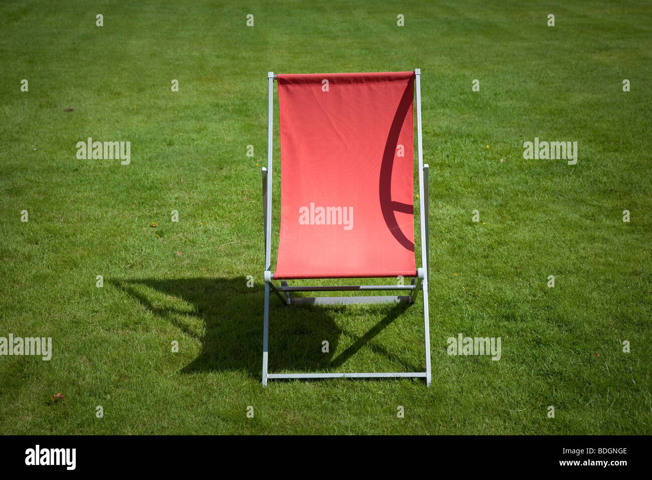 Red deck chair on lawn Stock Photo - Alamy
