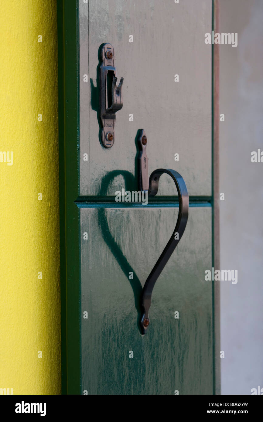 Brightly coloured yellow and green shutters with heart shape lock ...