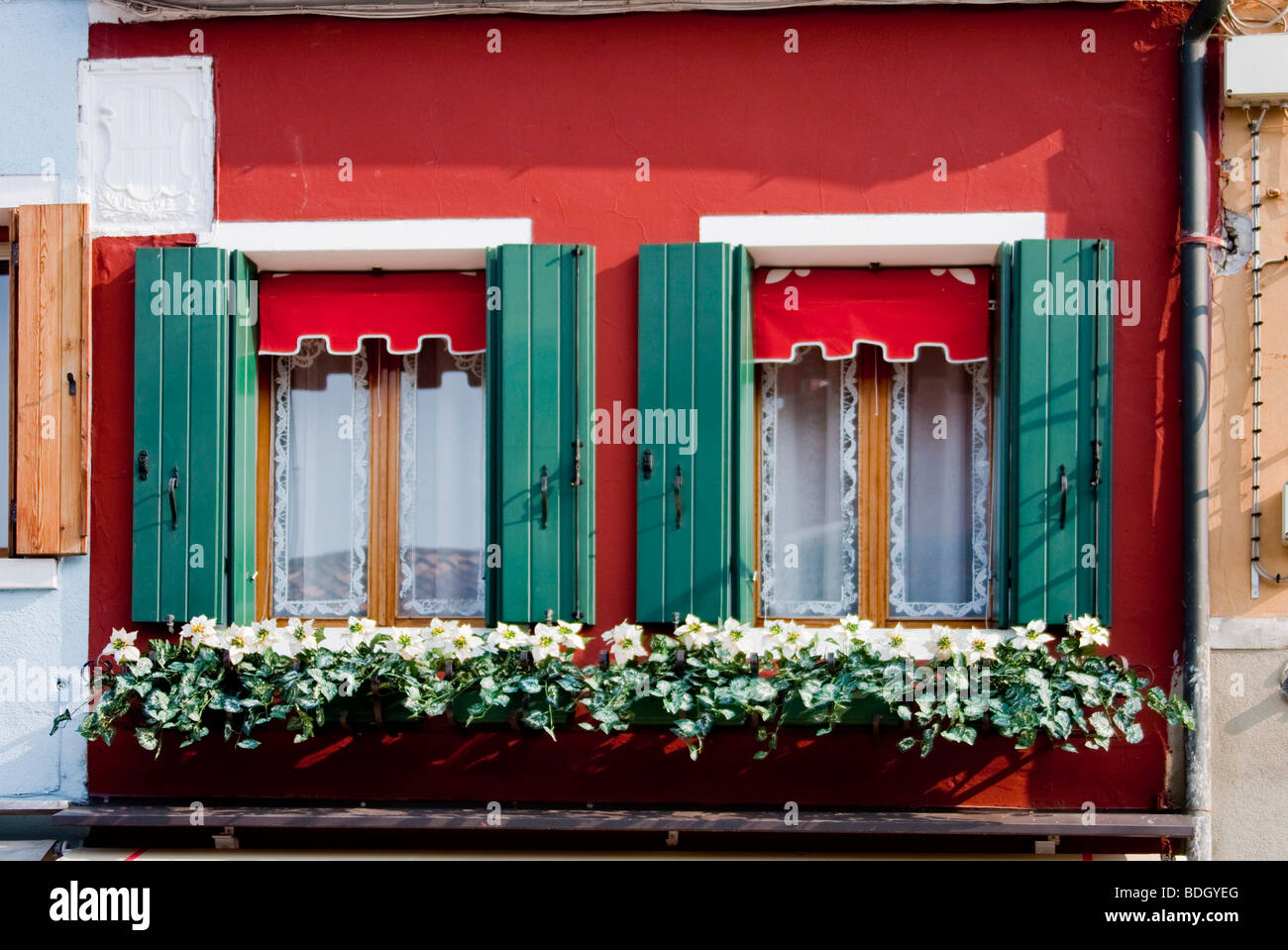 Brightly coloured red House with green shutters in Burano, Venice ...