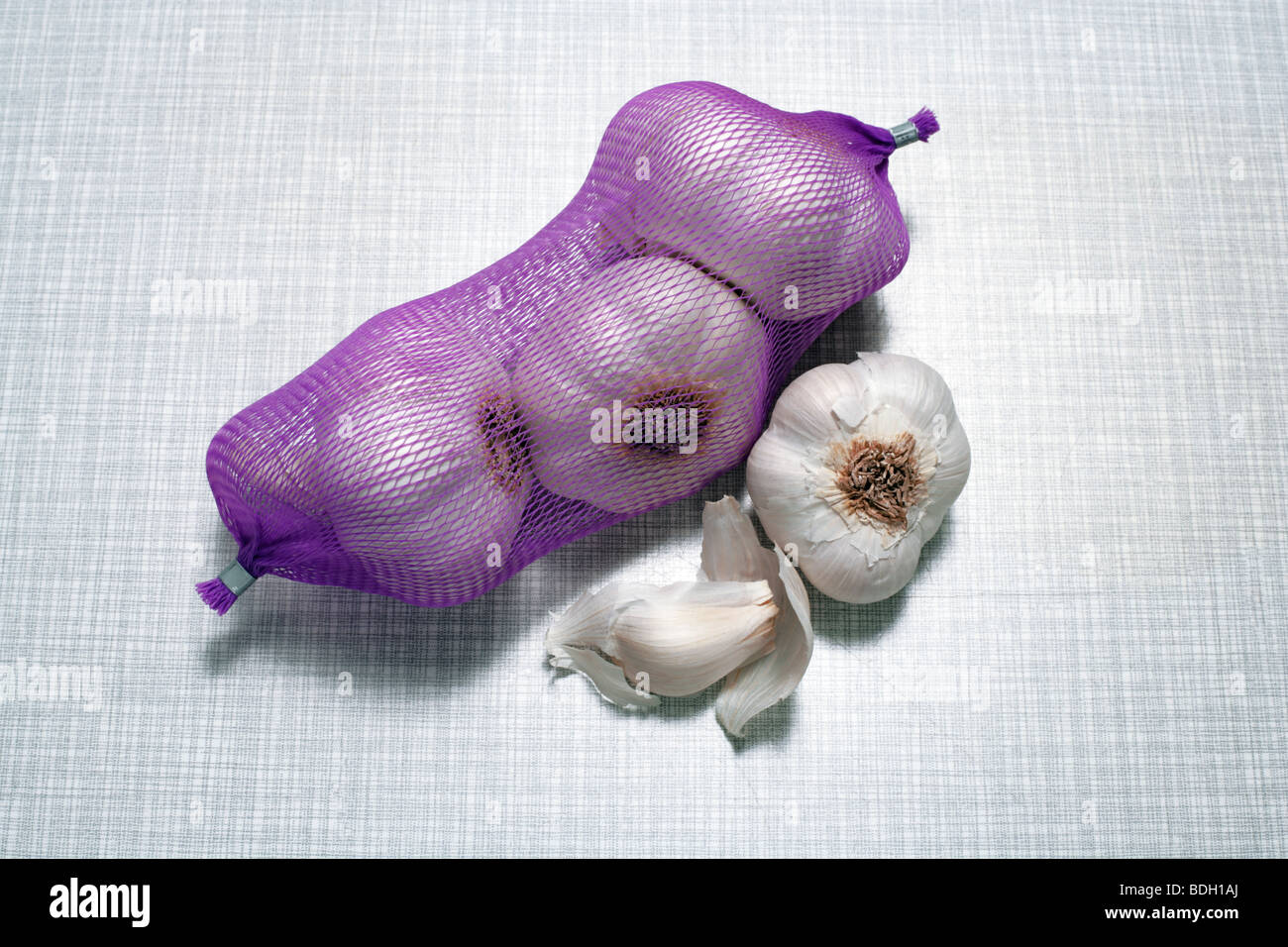 Garlic in the violet net on kitchen desk top Stock Photo - Alamy