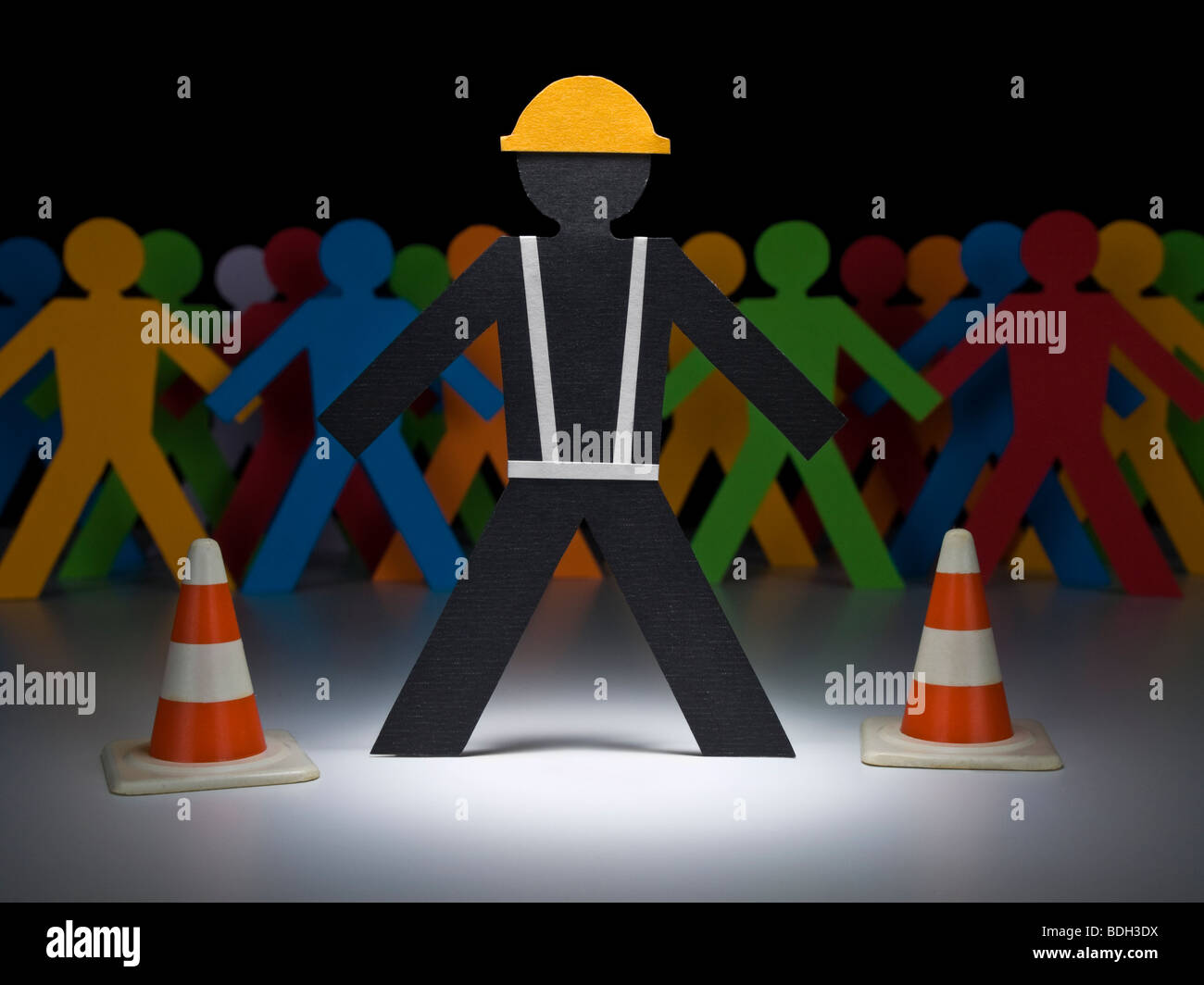 A paper construction worker stands under the spotlight before a ...