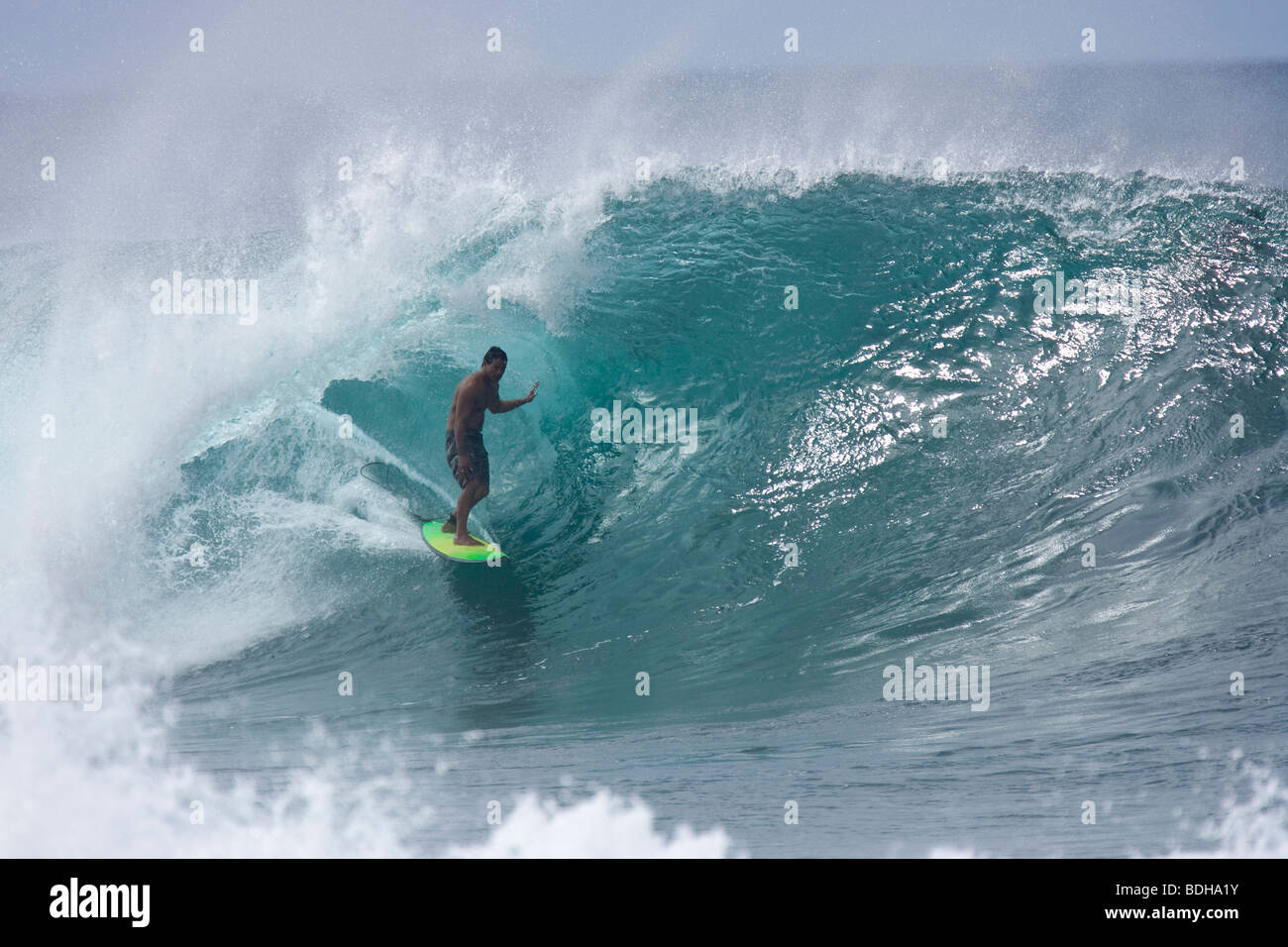 A young man surfing at Pipeline on the North Shore of Oahu, Hawaii ...