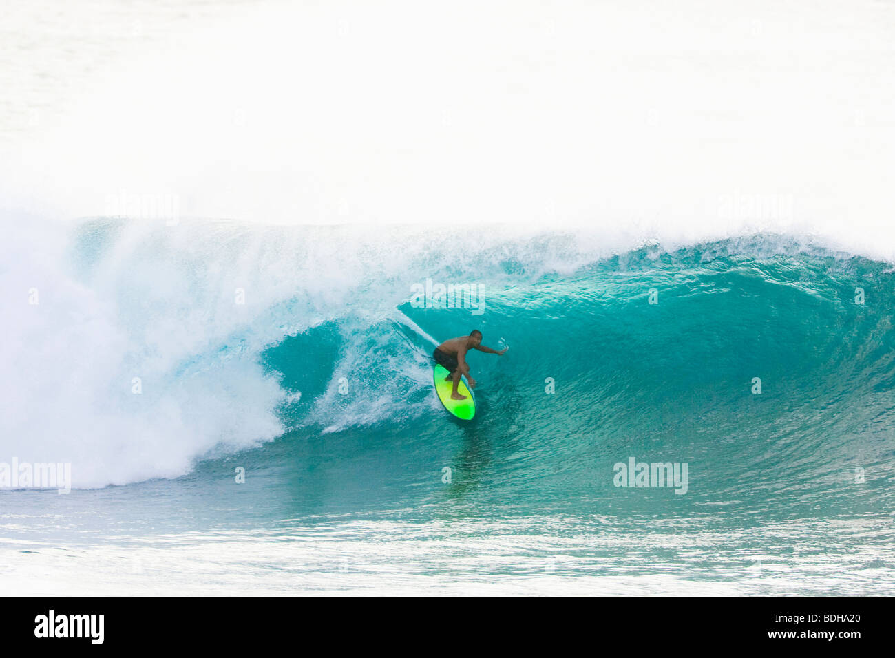 A young man surfing at Pipeline on the North Shore of Oahu, Hawaii ...