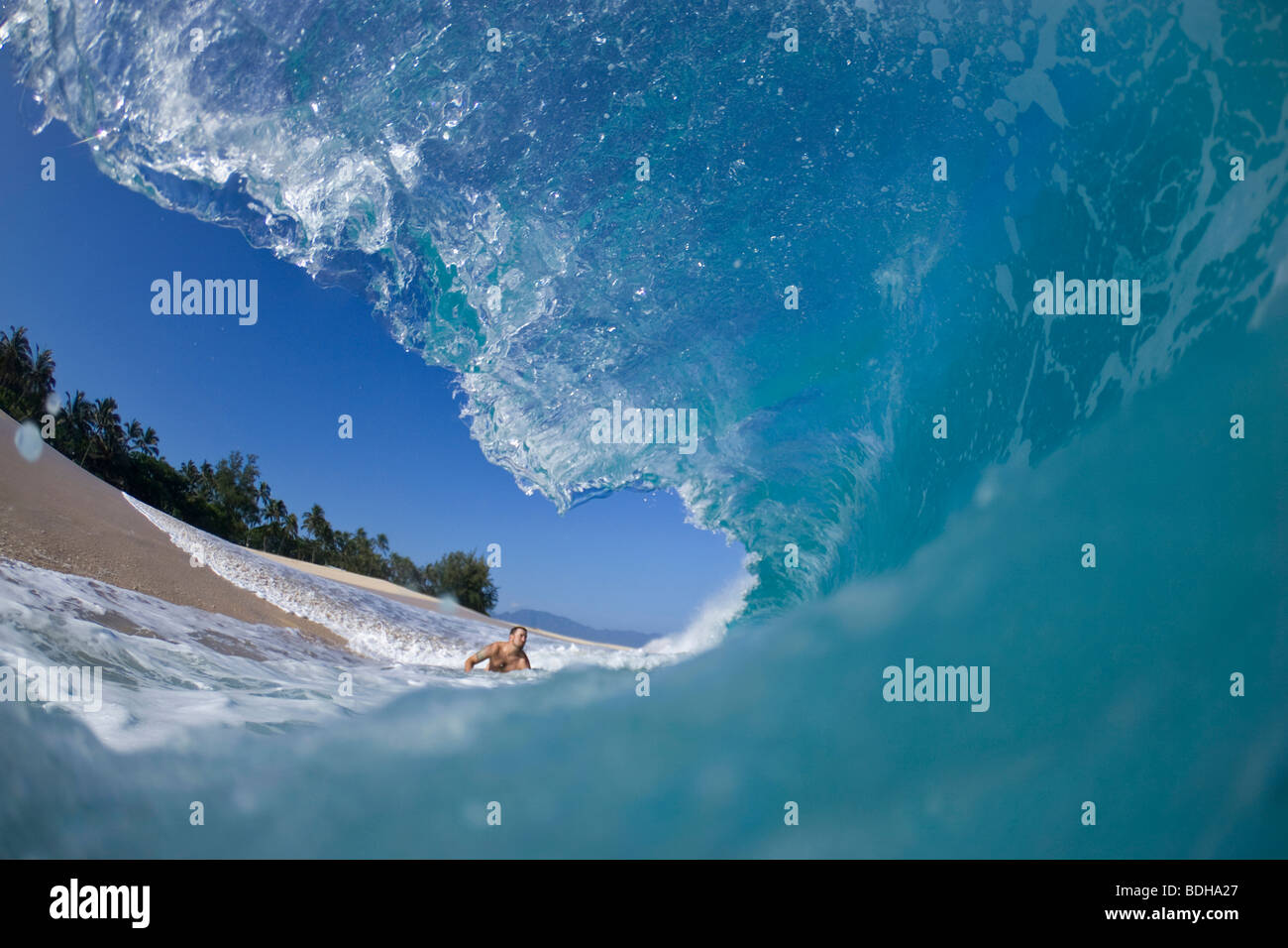 A young man about to be hit by wave at Keiki Beach on the North Shore ...
