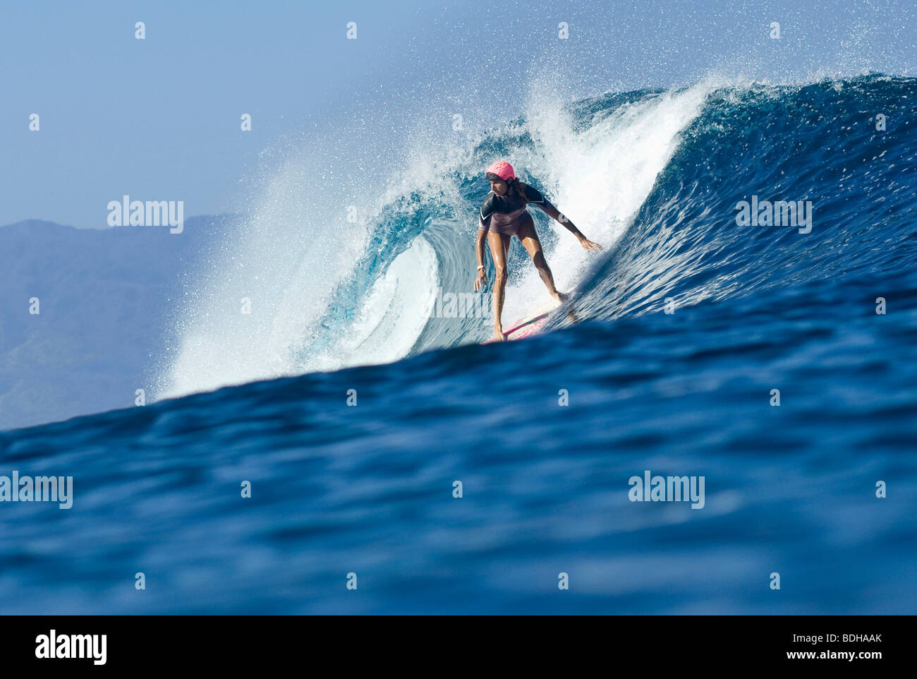 A water view of a woman dropping into a wave at Pipeline, on the north ...