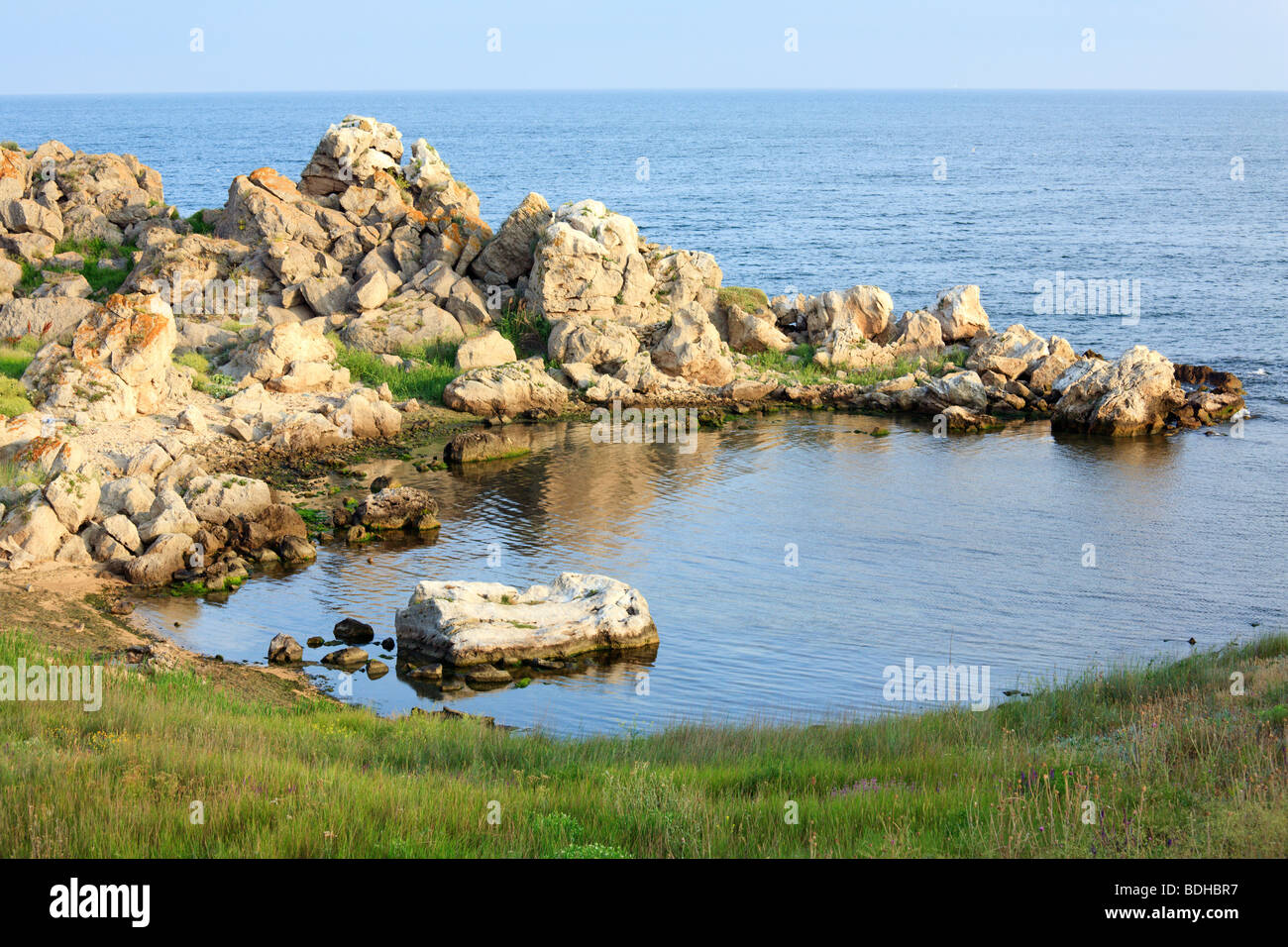 Small rocky sea lagoon and coastal grass Stock Photo - Alamy