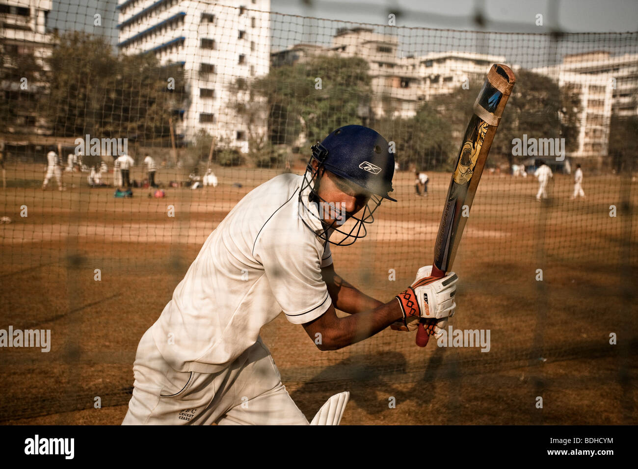 A young male Cricket player prepares to swing his cricket bat in a ...