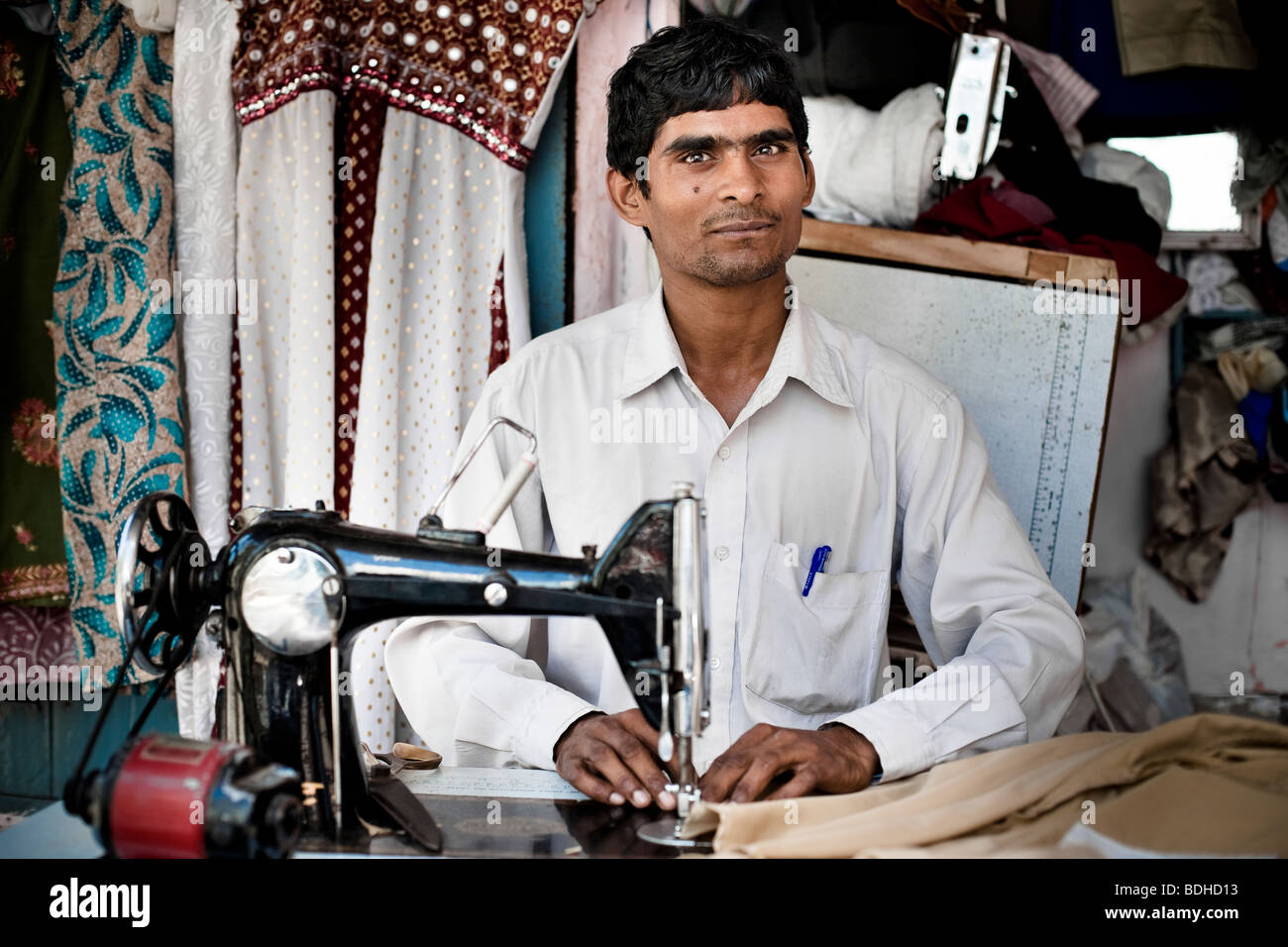 Portrait of a young man behind his sewing machine Stock Photo - Alamy