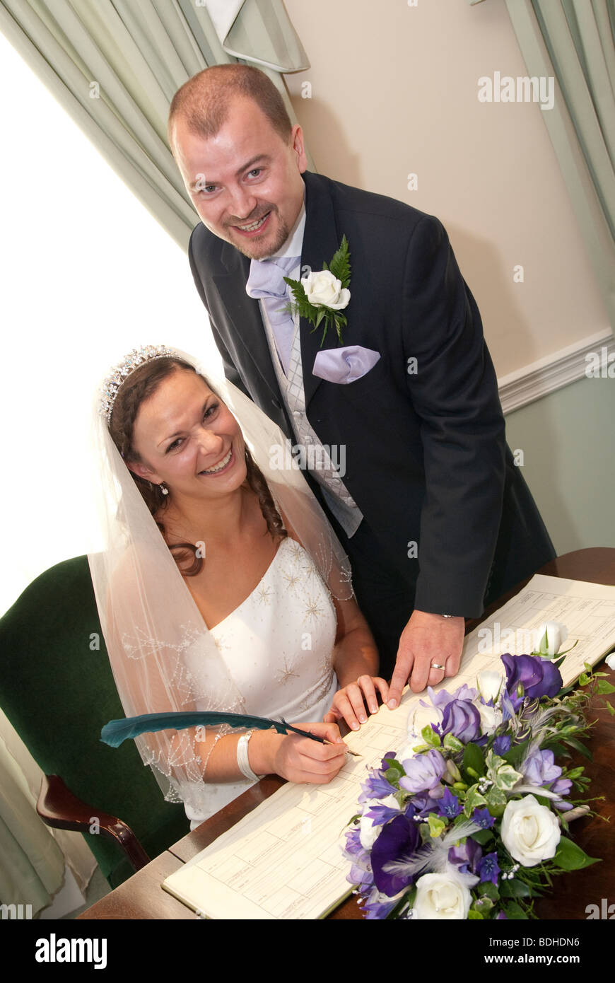 Bride and groom signing register in register office Stock Photo - Alamy