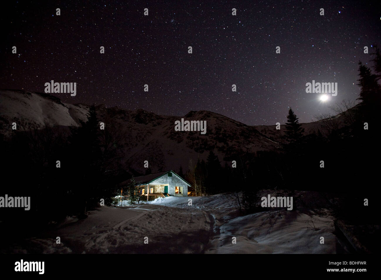 A moonlit trail outside a cabin shelter at night, with Tuckerman ravine ...