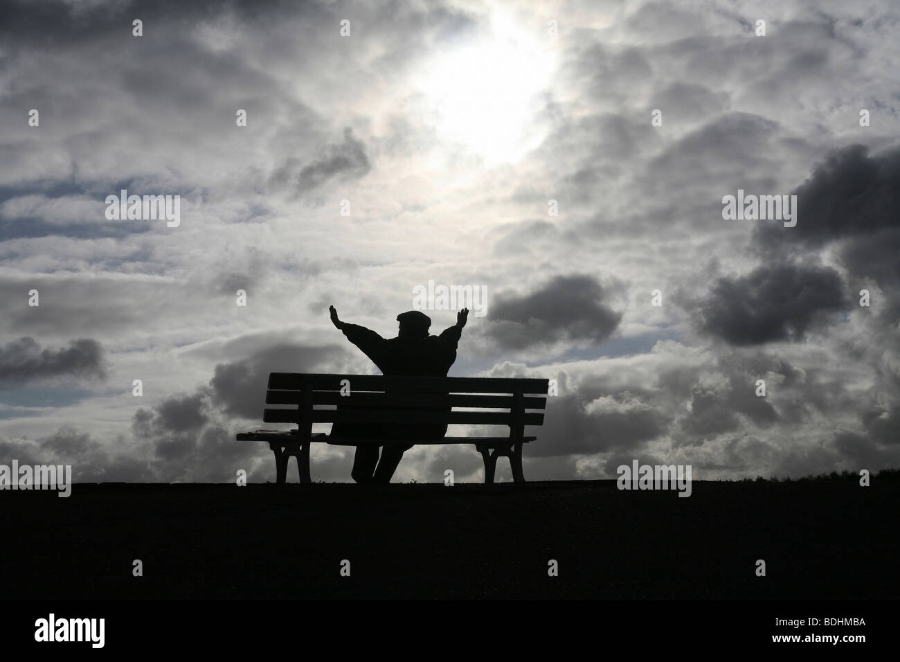 Silhouette of a man sitting on a bank Stock Photo - Alamy