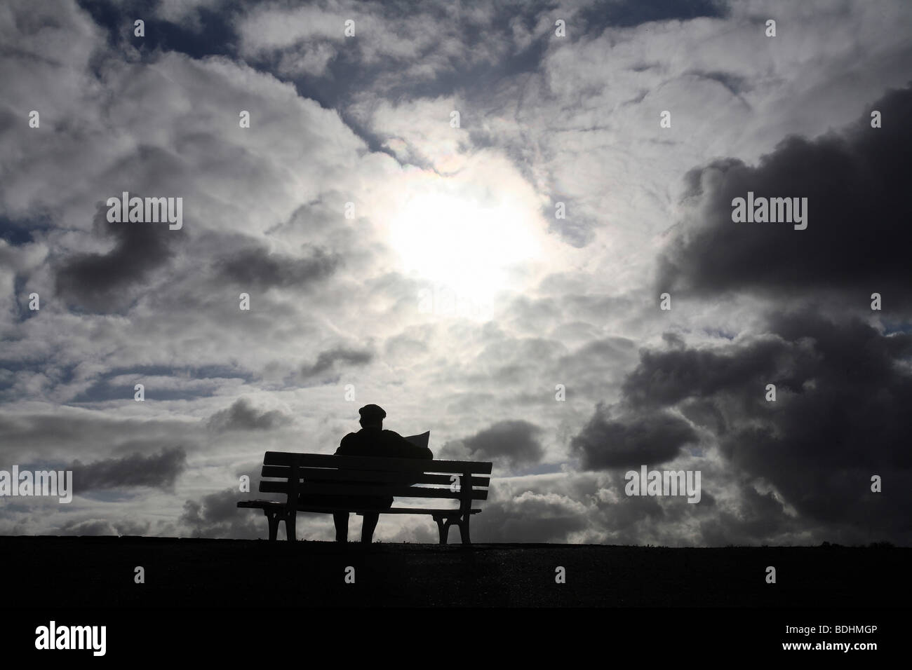 Silhouette of a man sitting on a bank Stock Photo - Alamy