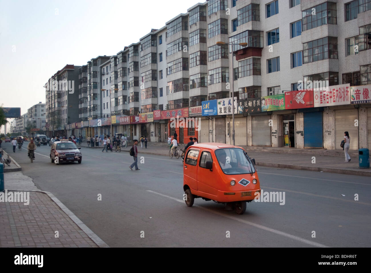 A strange looking single seat car and street scene in De Hui city ...