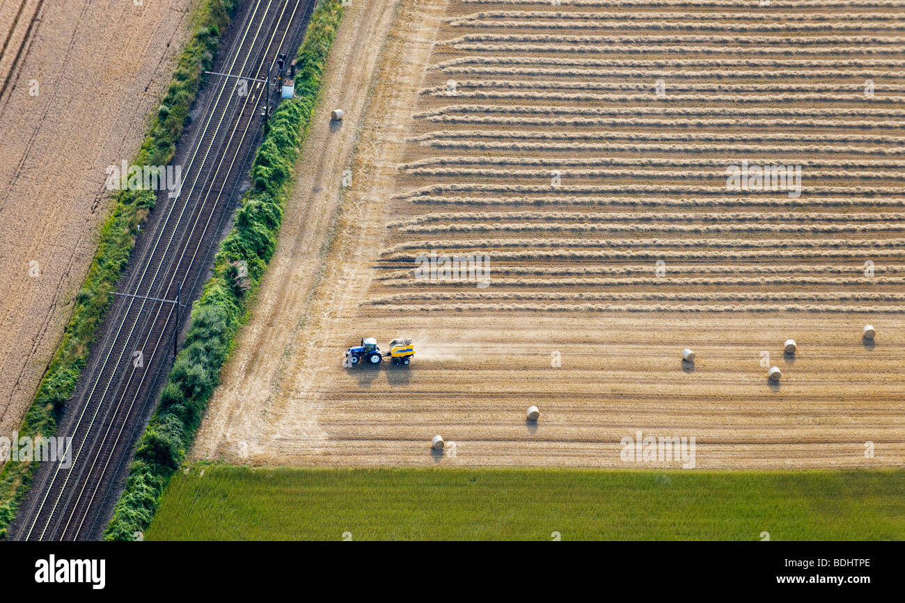 Aerial View : Tractor baling in a field along a railroad Stock Photo ...