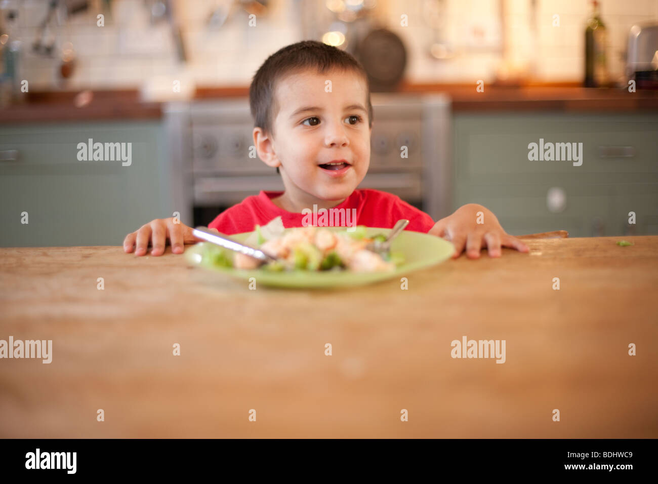 Boy sitting at table not eating a plate of food Stock Photo - Alamy