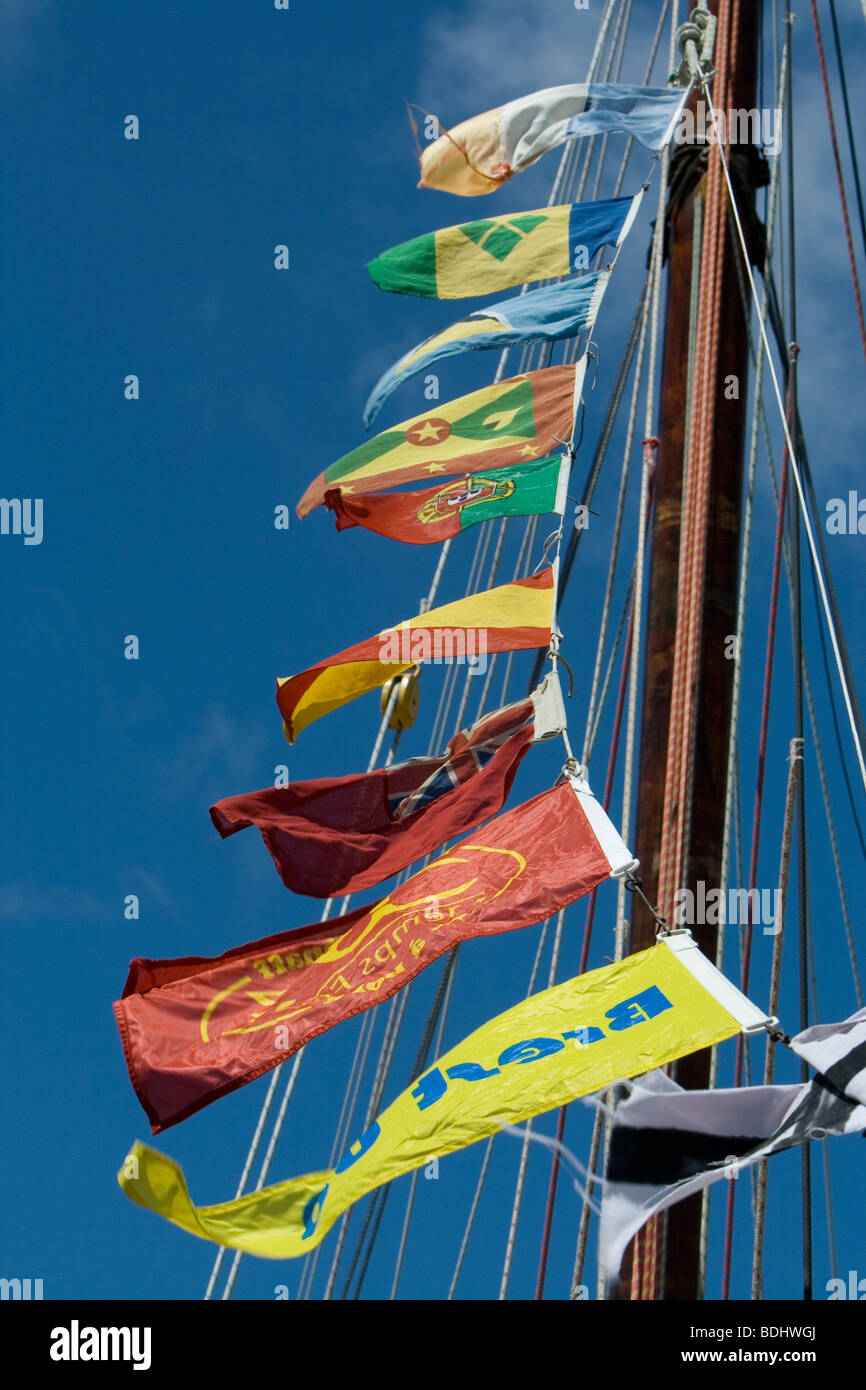 Colourful flags flying from wooden mast of boat against blue sky Stock ...