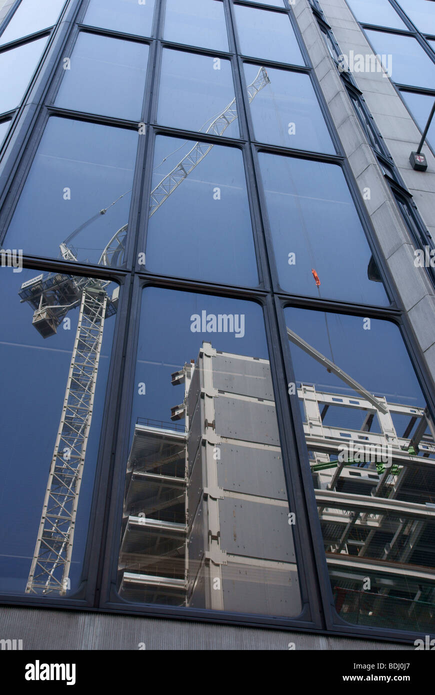 Reflections of building construction in a city office window Stock ...