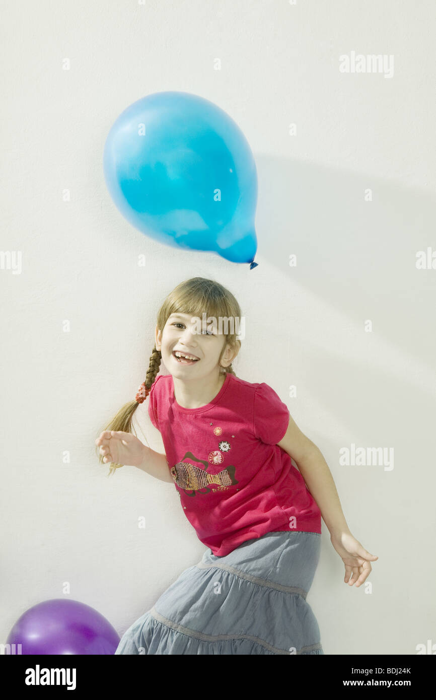 little happy giggle girl playing with colour balloons. Girl celebrates ...