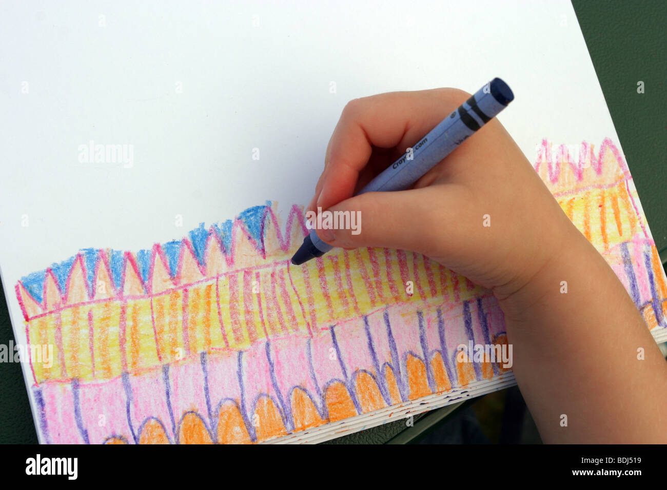 A young child using crayons Stock Photo - Alamy