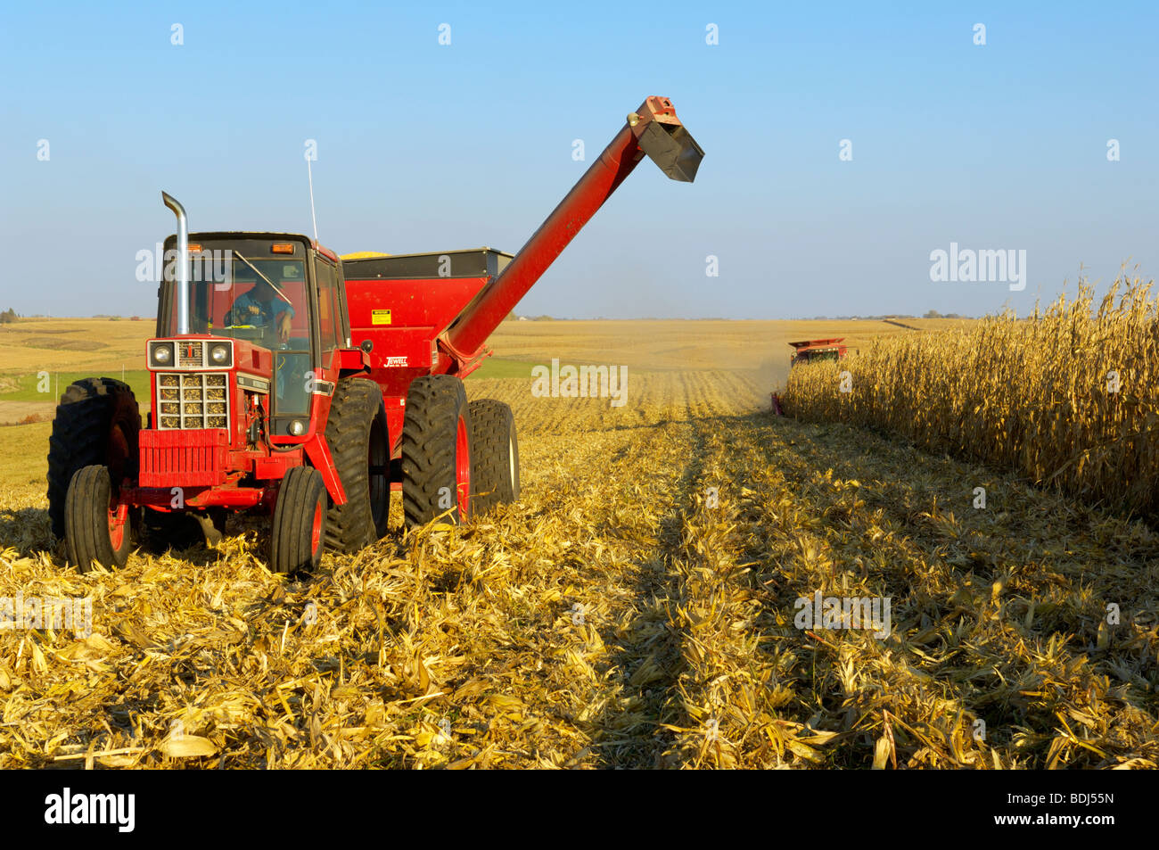 Agriculture - A tractor with a full grain cart pulls away from a ...
