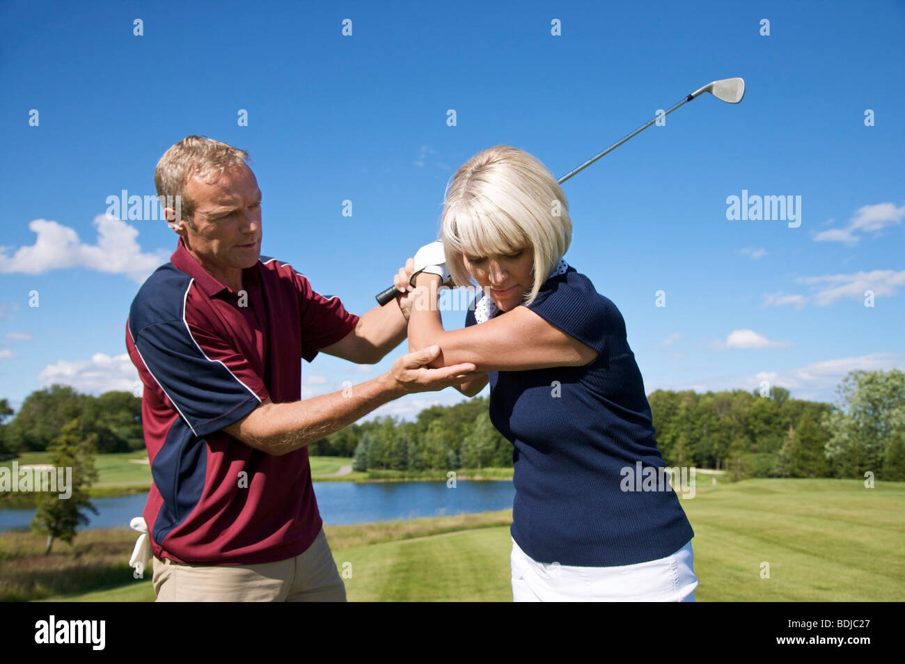 Man Helping Woman With Her Golf Swing Stock Photo - Alamy