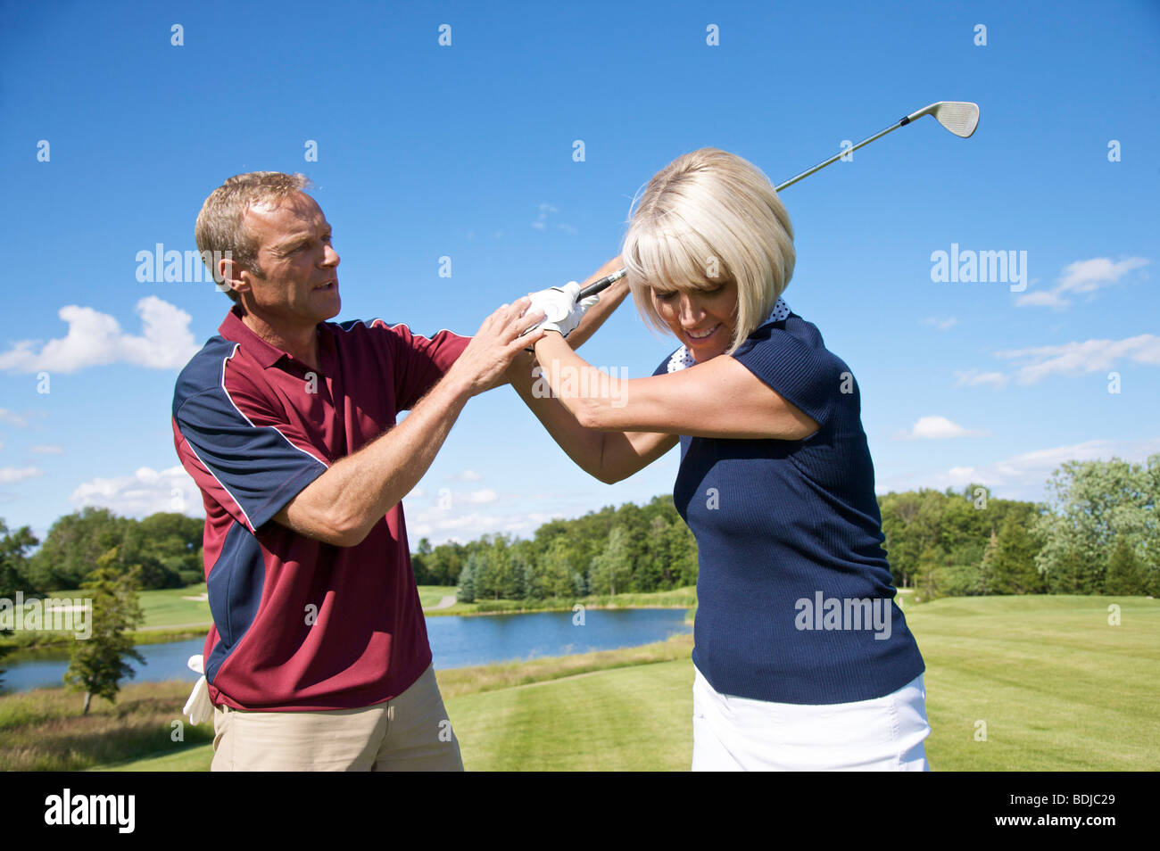 Man Helping Woman With Her Golf Swing Stock Photo - Alamy