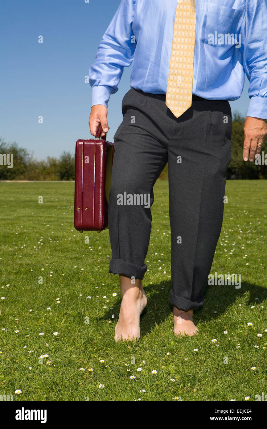 Businessman Walking Barefoot on Grass Stock Photo - Alamy