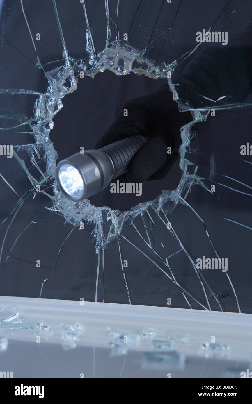 Hand Holding Flashlight Through Broken Window Stock Photo - Alamy