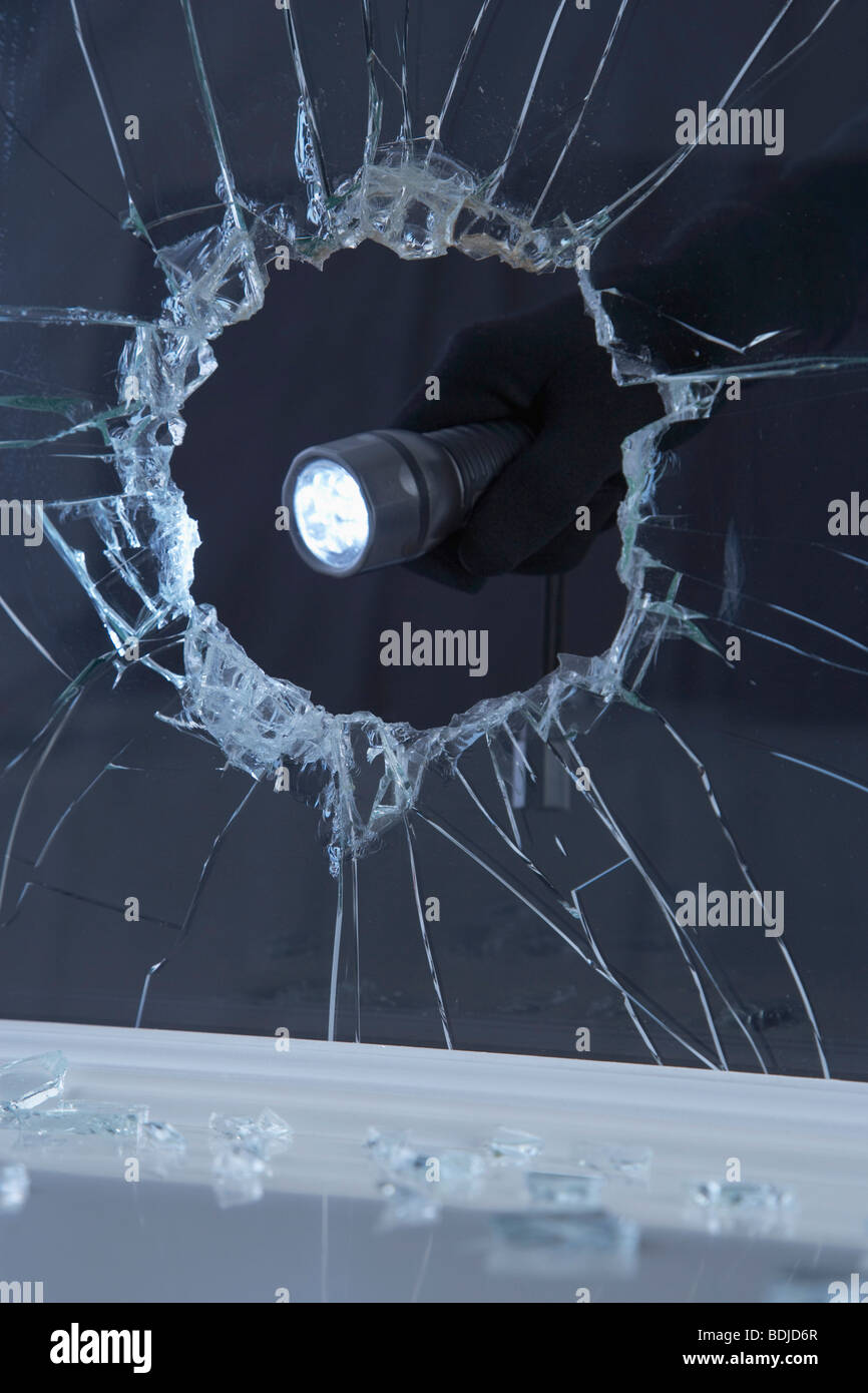 Hand Holding Flashlight Through Broken Window Stock Photo - Alamy